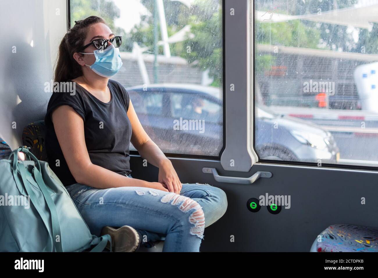 Female wearing a mask preventing contagion sitting in a bus, social ...