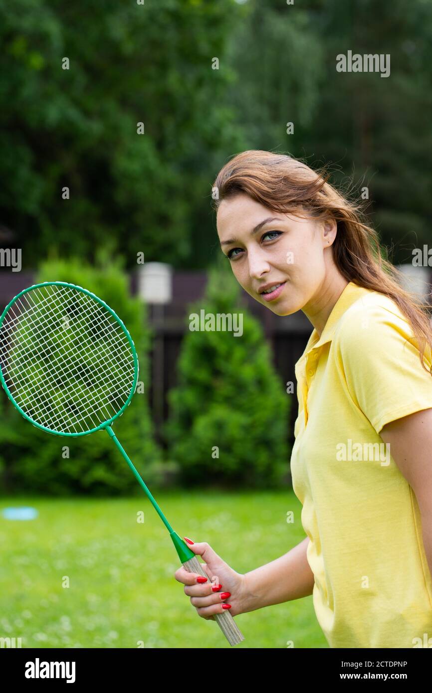 Beautiful female badminton player with racket in hands outdoors. Sport ...