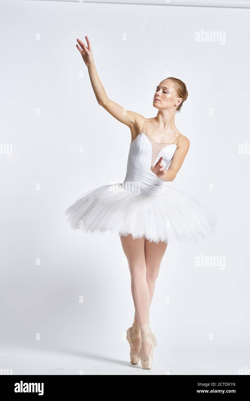 Ballerina in a white tutu dance performed on a light background Stock ...