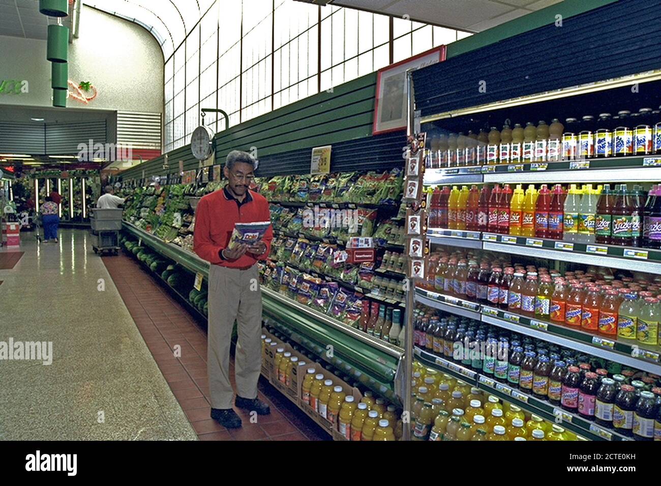 June 2000 - Shopper Looks Over Packaged Lettuce In Grocery Store Stock ...