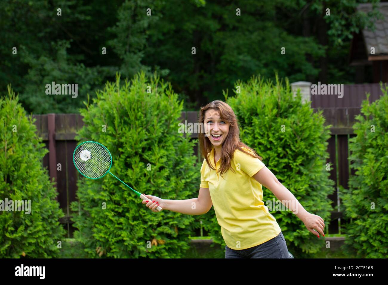 Young enthusiastic woman playing badminton outdoors. Badminton player ...