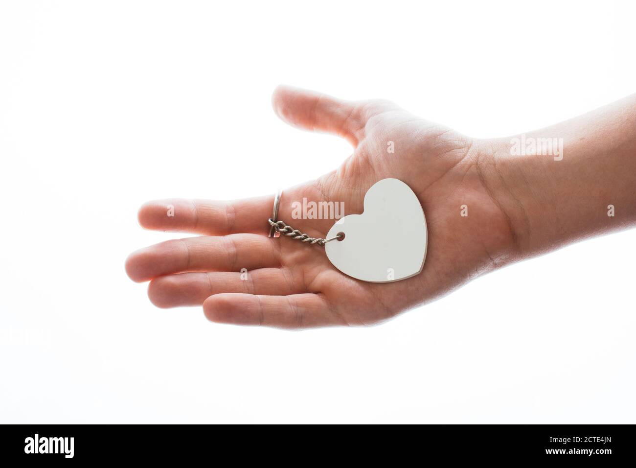 Heart shaped white object in hand on white background Stock Photo - Alamy