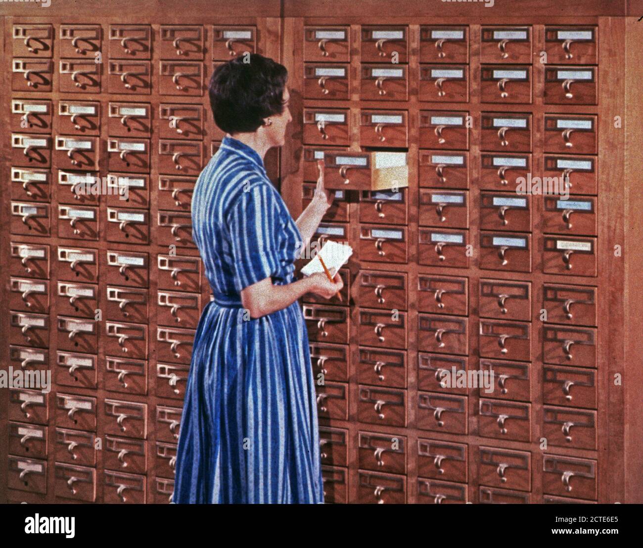 Woman using a large card catalog in a library ca. 1963 Stock Photo - Alamy