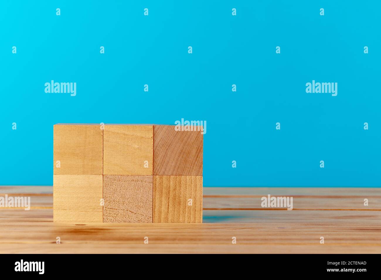 Stacked wooden blocks on wooden desk against blue background Stock ...