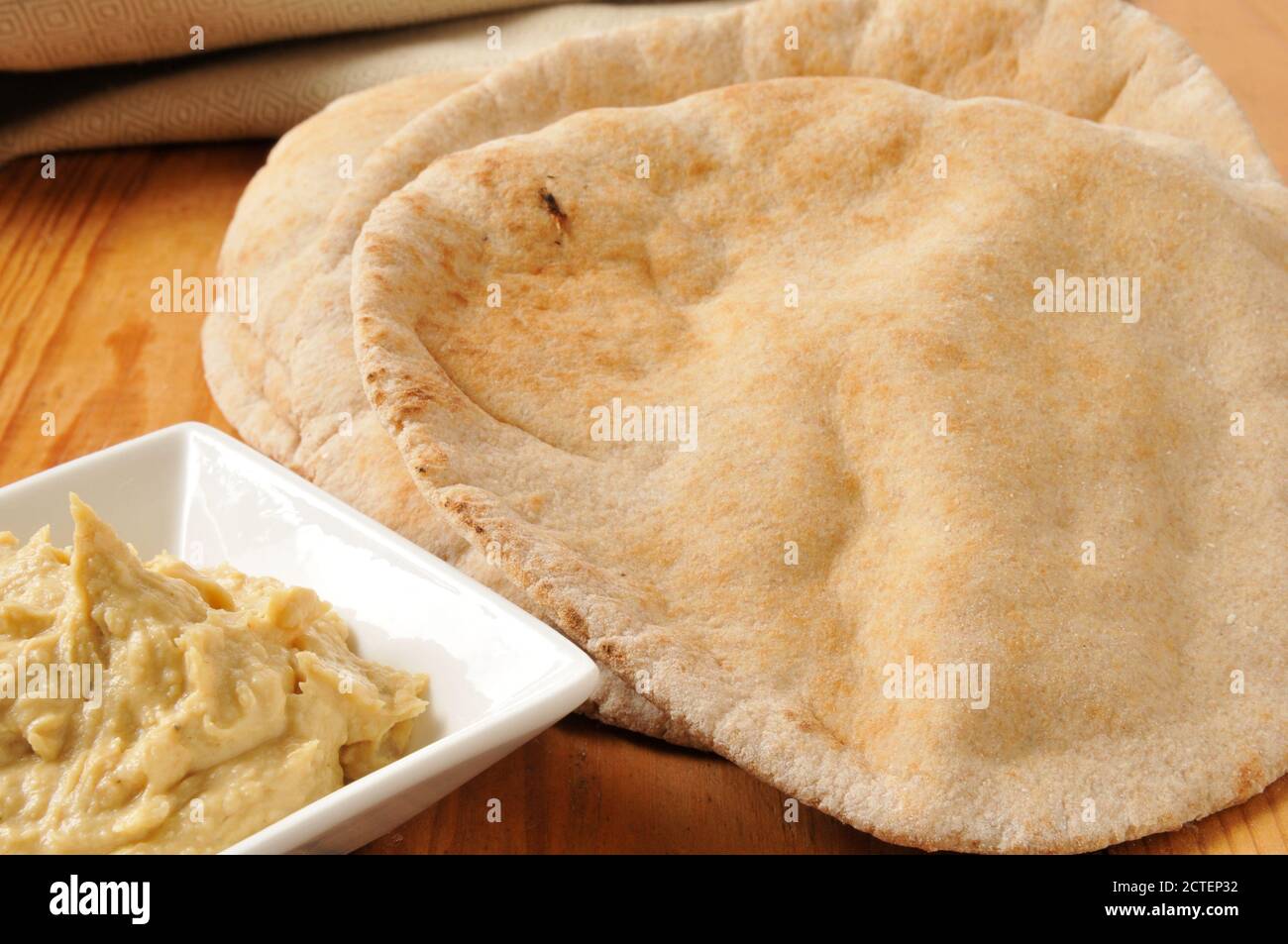 Whole wheat pita bread with garlic hummus closeup Stock Photo - Alamy