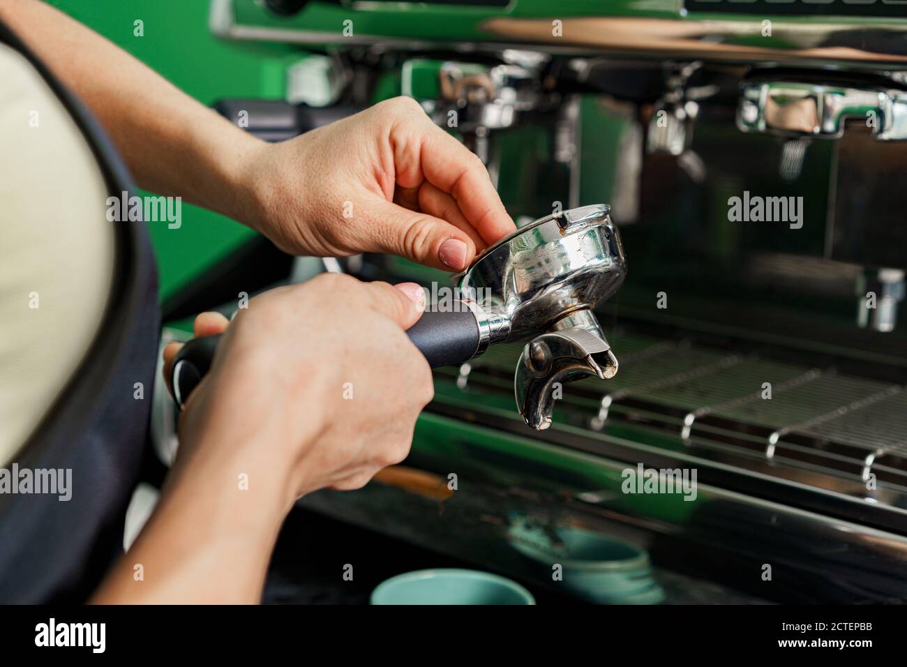 Woman coffee shop worker preparing coffee on professional coffee ...