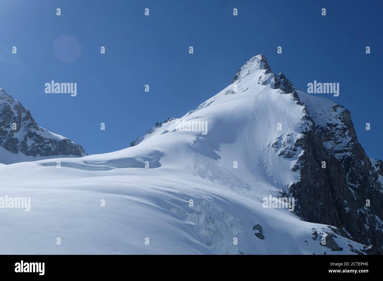 Snow covered l'eveque, a mountain peak in the middle of glaciers above ...