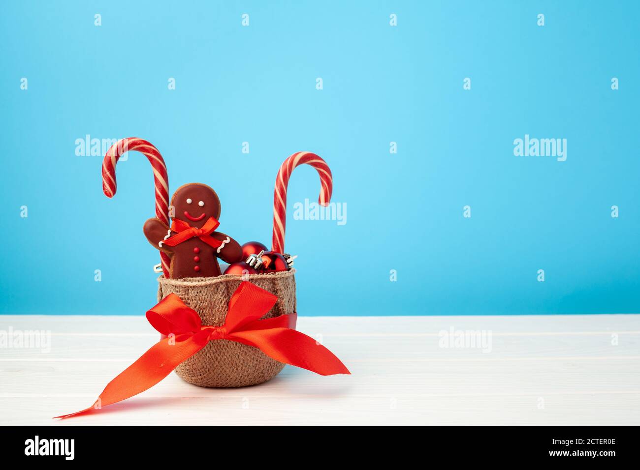 Gingerbread man and candy canes in a basket against blue Stock Photo ...