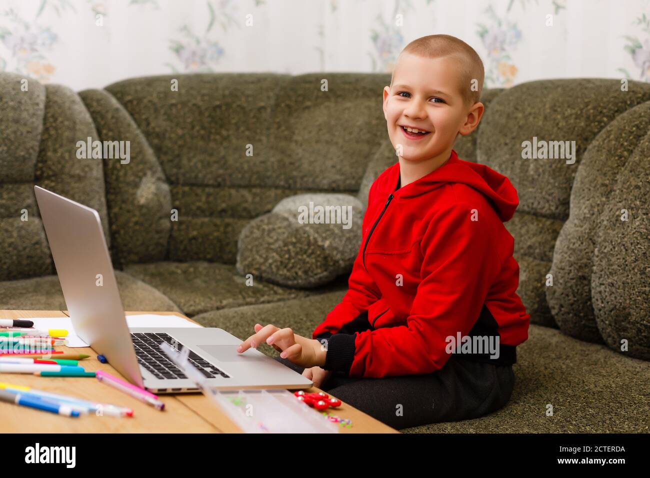 Happy boy sitting at his desk With laptop computer Stock Photo - Alamy