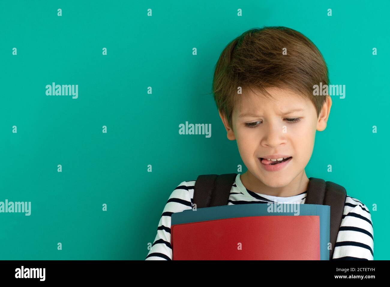 Schoolboy with a bored face with copy space. Pupil with a backpack and ...