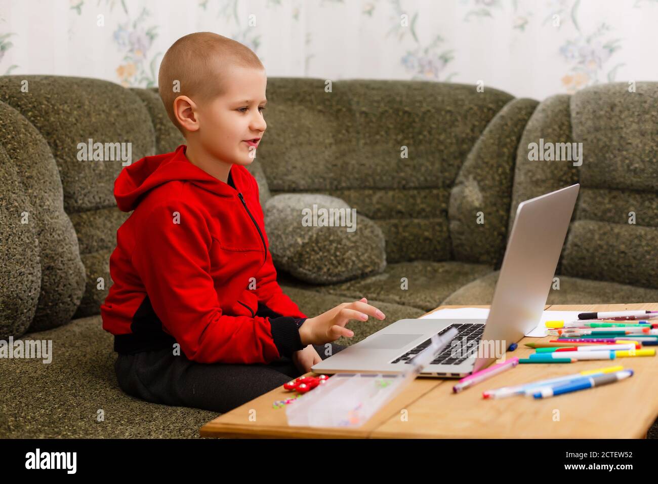 Happy boy sitting at his desk With laptop computer Stock Photo - Alamy