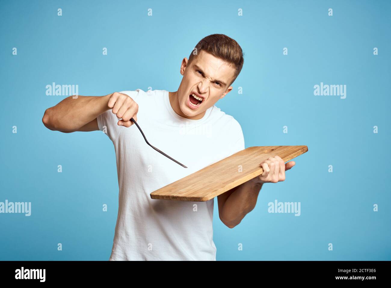 energetic guy with wooden kitchen board and spatula fun emotions Stock ...