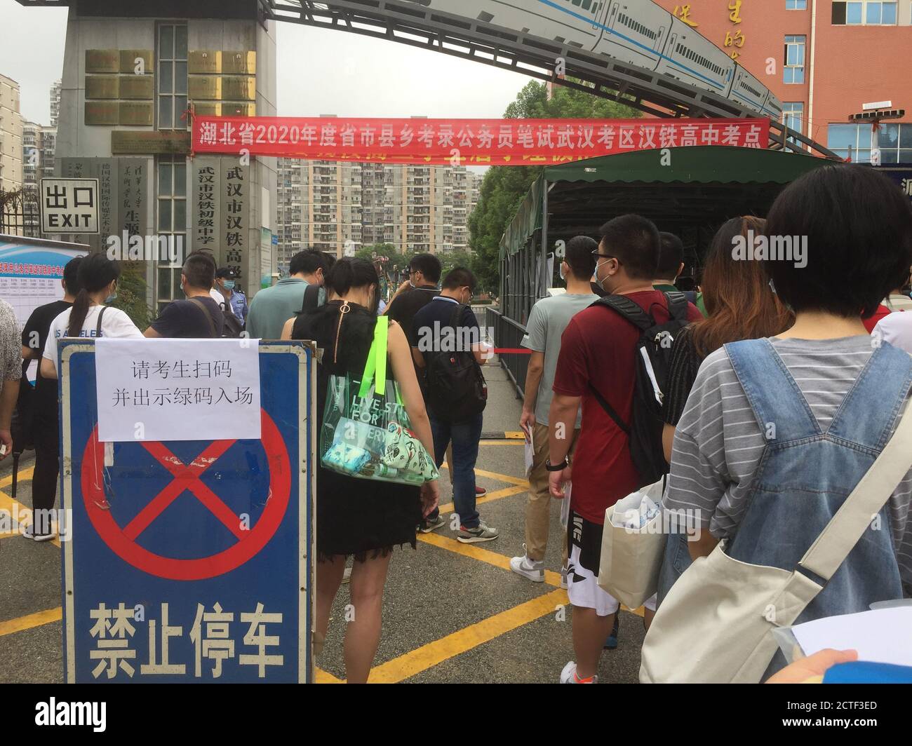 Candidates of civil servants wait outside a testing center, preparing ...