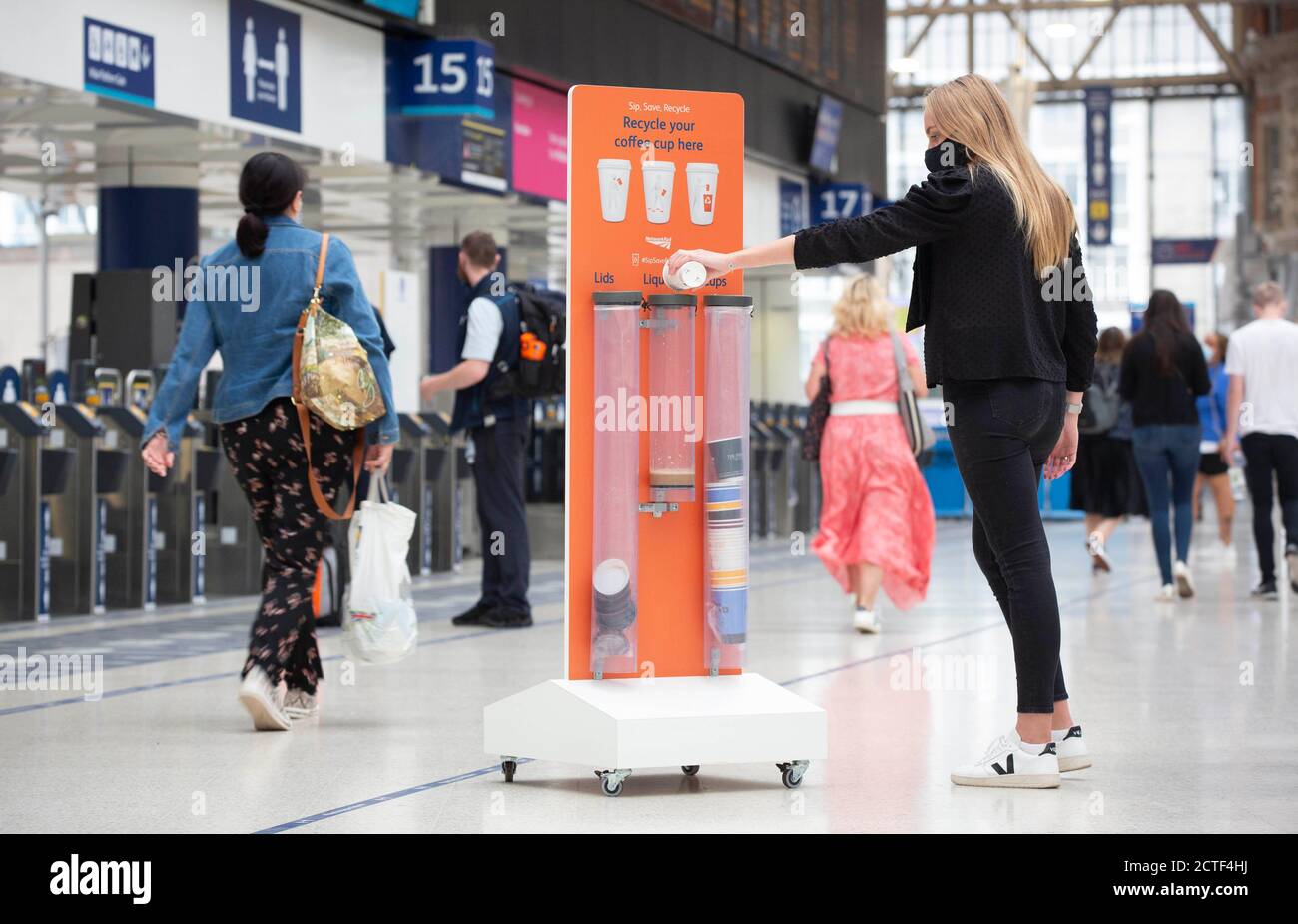 EDITORIAL USE ONLY A passer-by uses a bin specially designed to recycle ...
