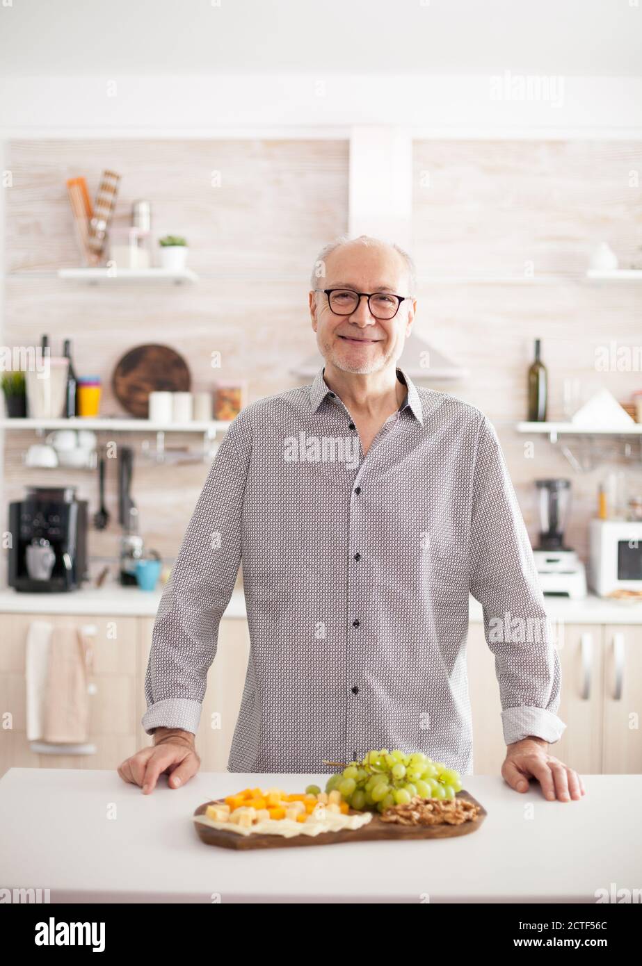 Happy elderly aged man smiling looking at camera in kitchen with tasty ...