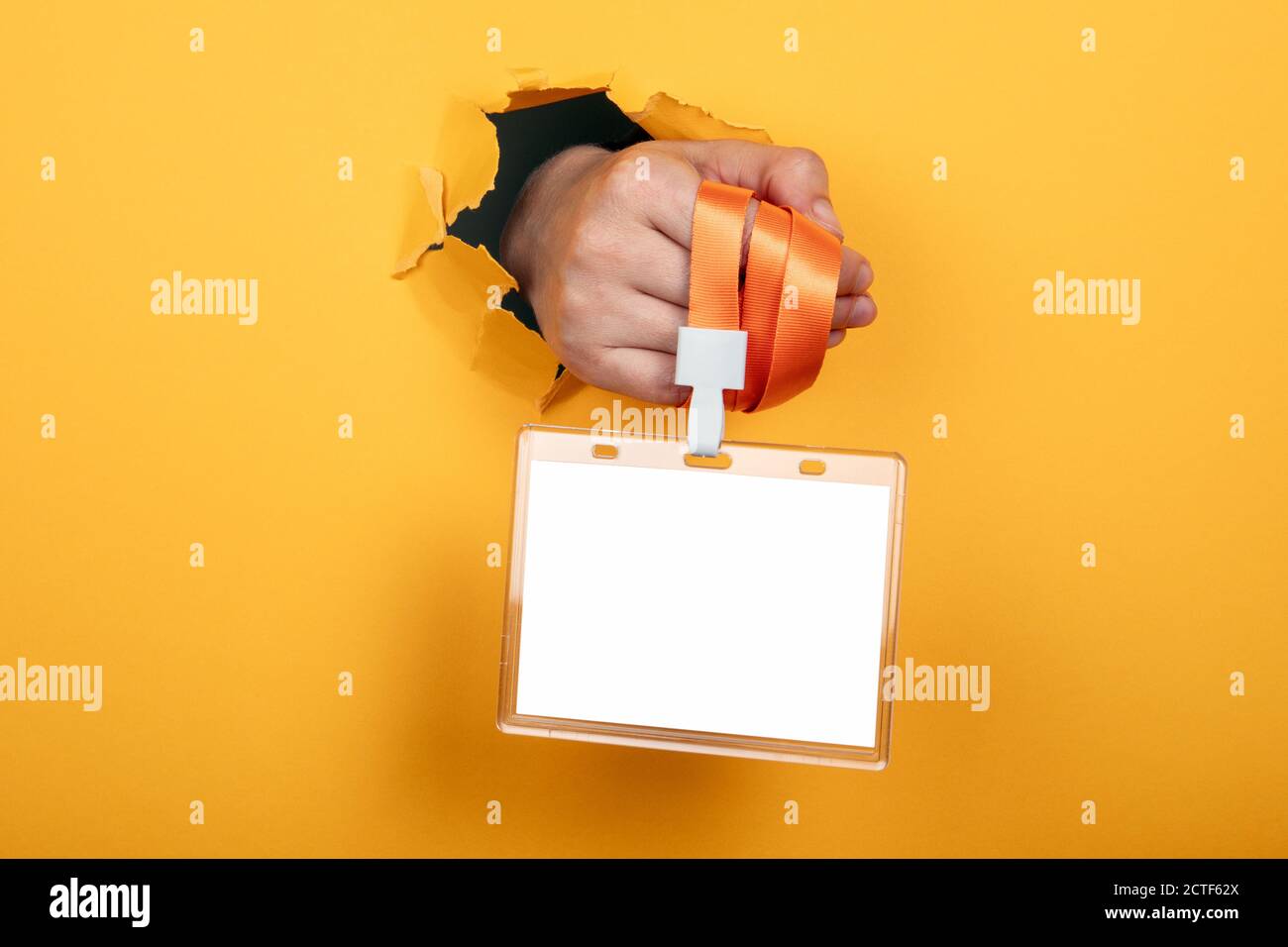 Blank badge mockup. Security tag with orange neck band. Hand on a paper ...
