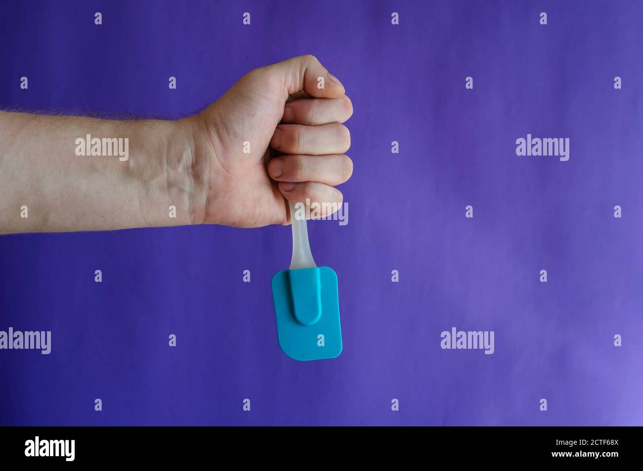Kitchen silicone spatula in hand. A male hand holds a kitchen spatula ...