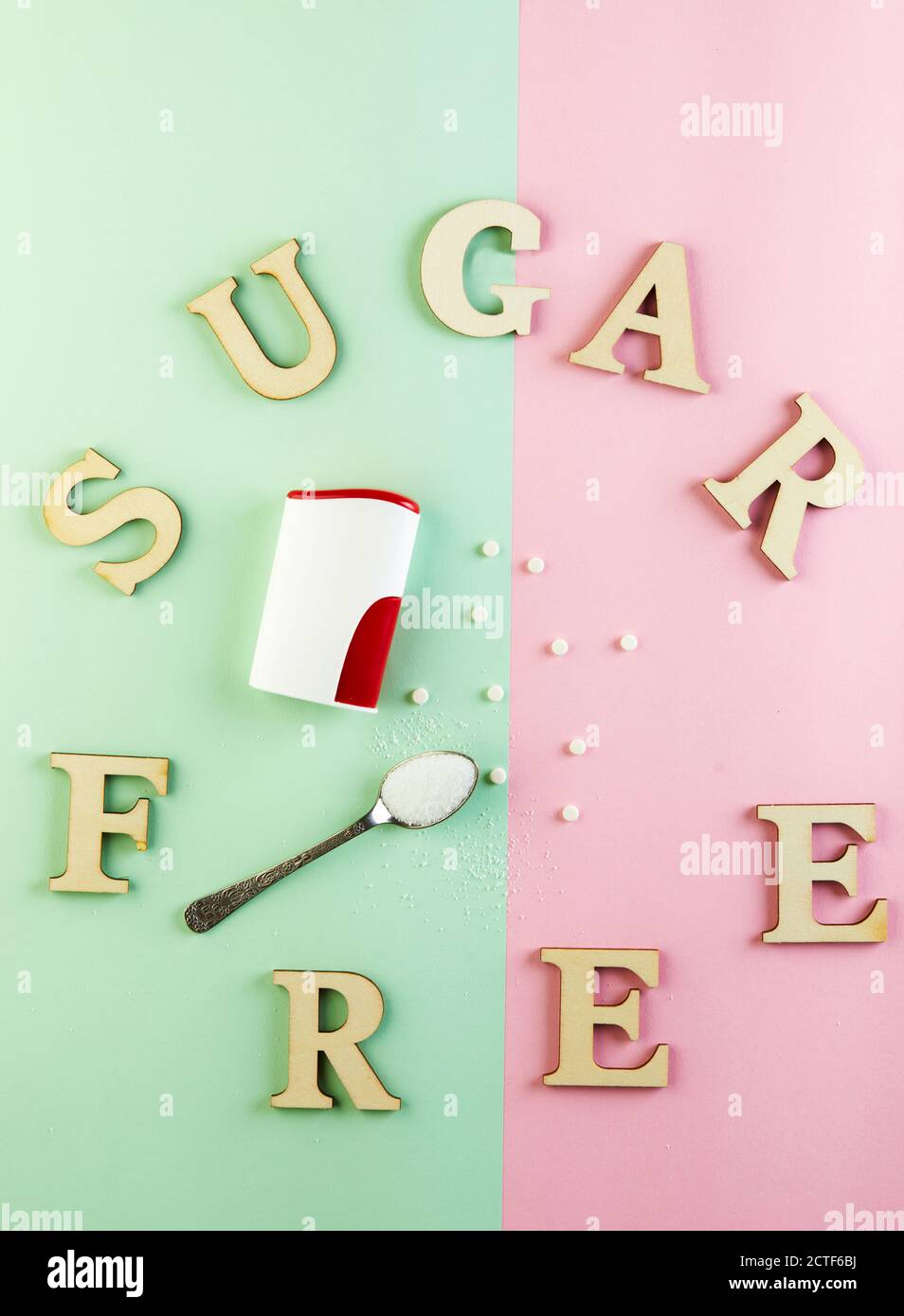 Sugar substitute pills and natural sweetener in powder on a green-pink ...