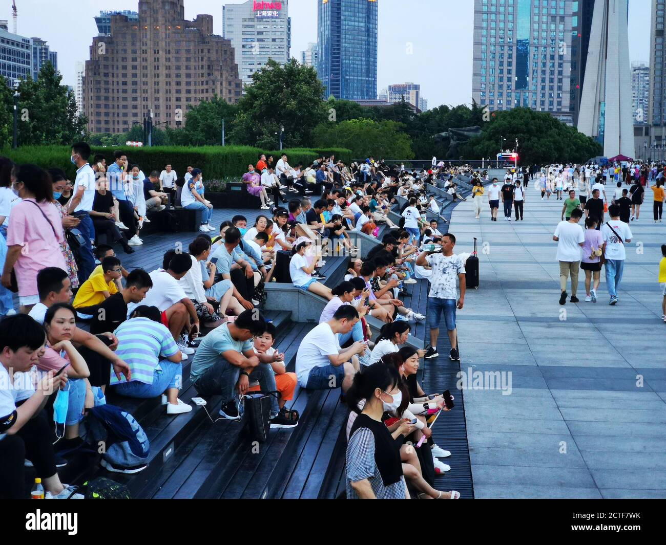 A group of tourists sit on the steps at sunset, as the temperature was ...