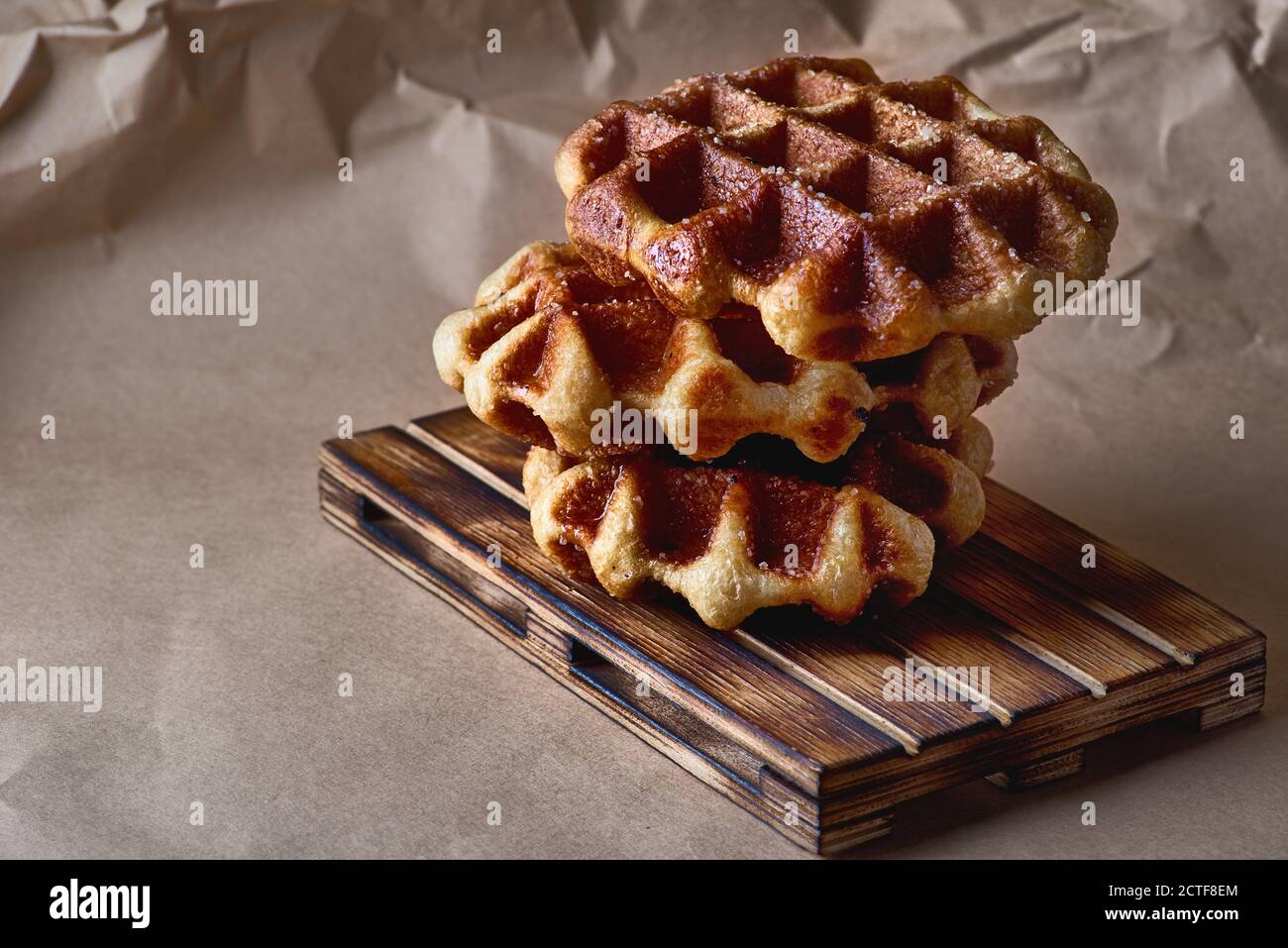 Belgian waffles on brown paper and wooden tray Stock Photo - Alamy