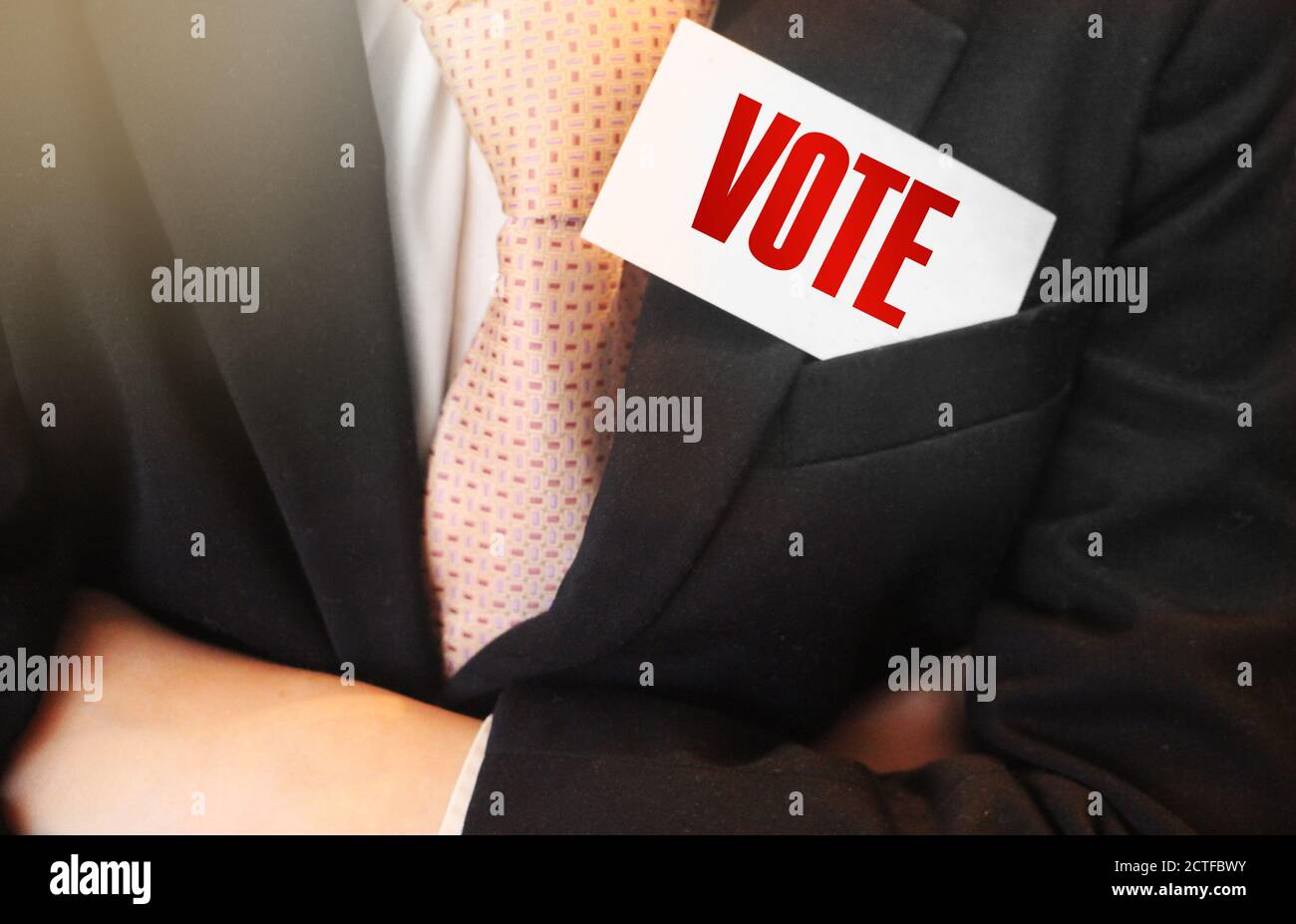 Businessman has a card with word Vote in upper pocket of suit ...
