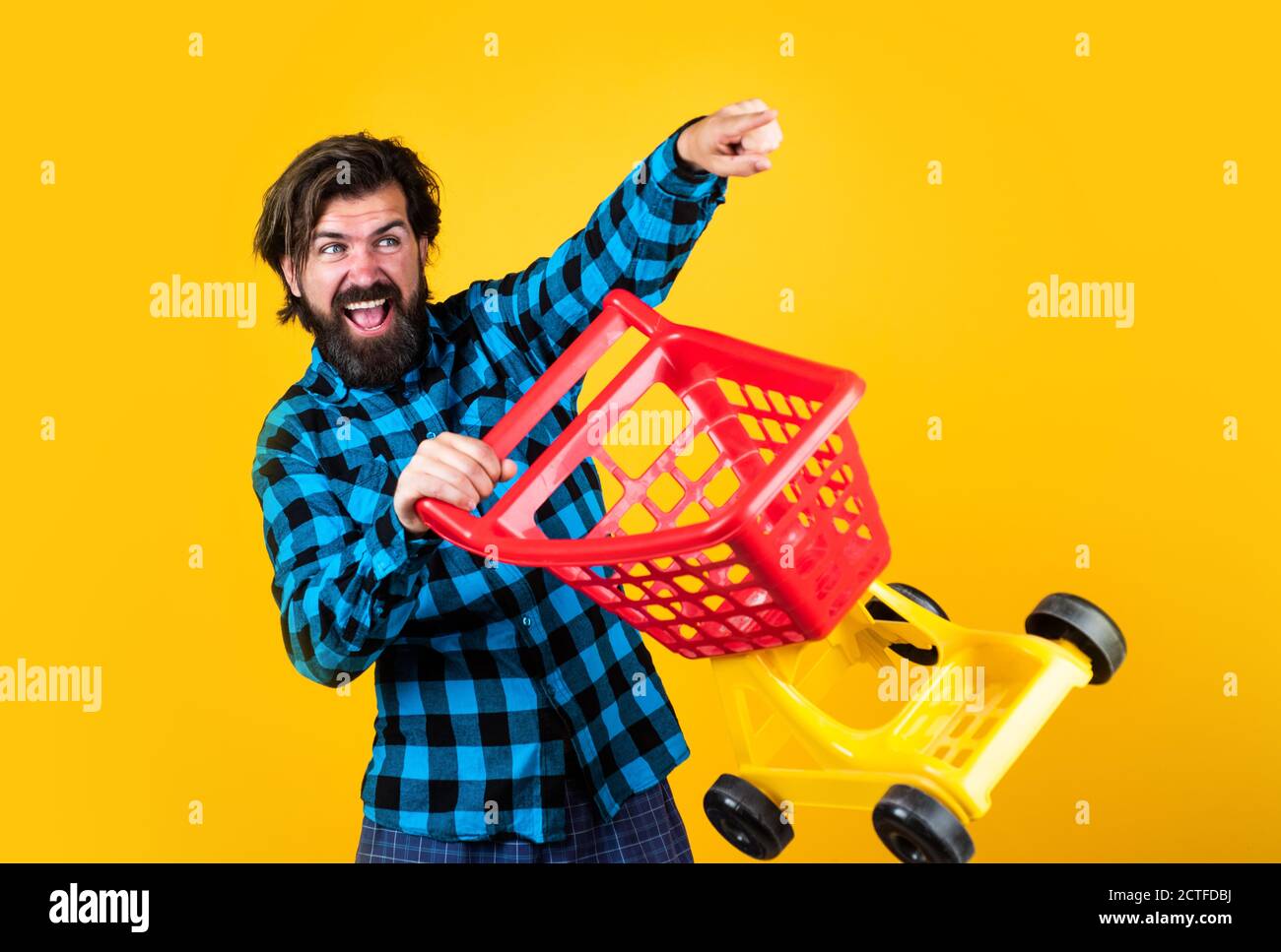 Handsome happy man shopping in a supermarket with cart, shopaholic ...