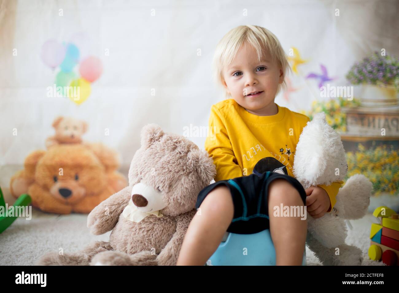 Cute toddler boy, potty training, playing with his teddy bear on potty ...