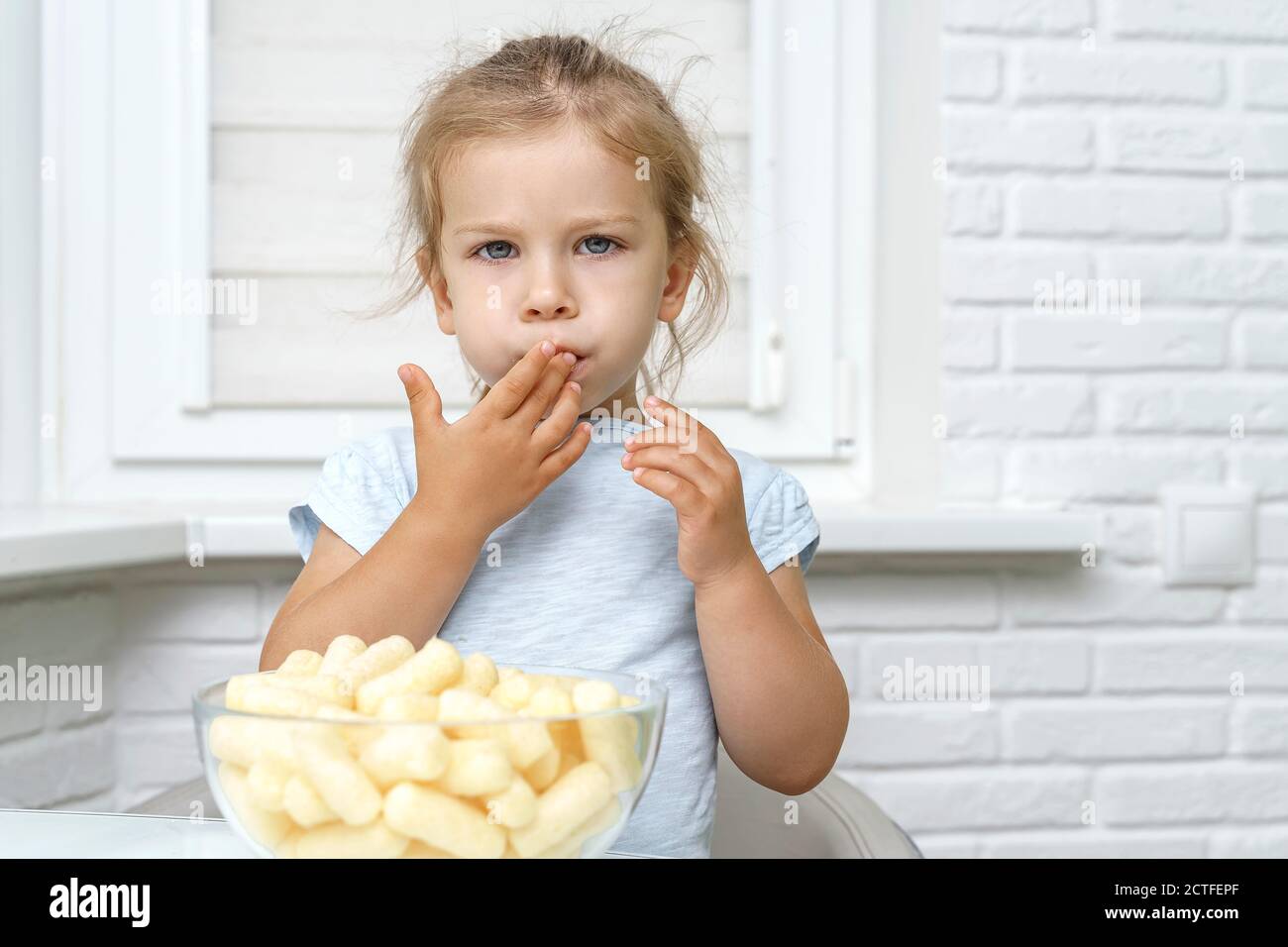 child eating corn sticks at the kitchen table Stock Photo - Alamy