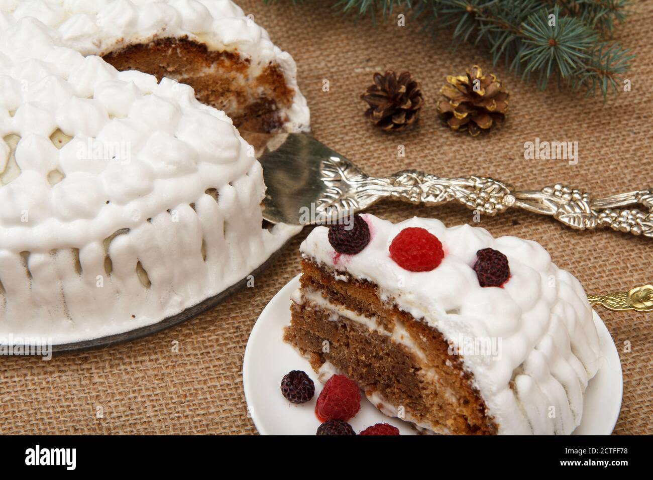 Sliced biscuit cake decorated with whipped cream and raspberries and a ...