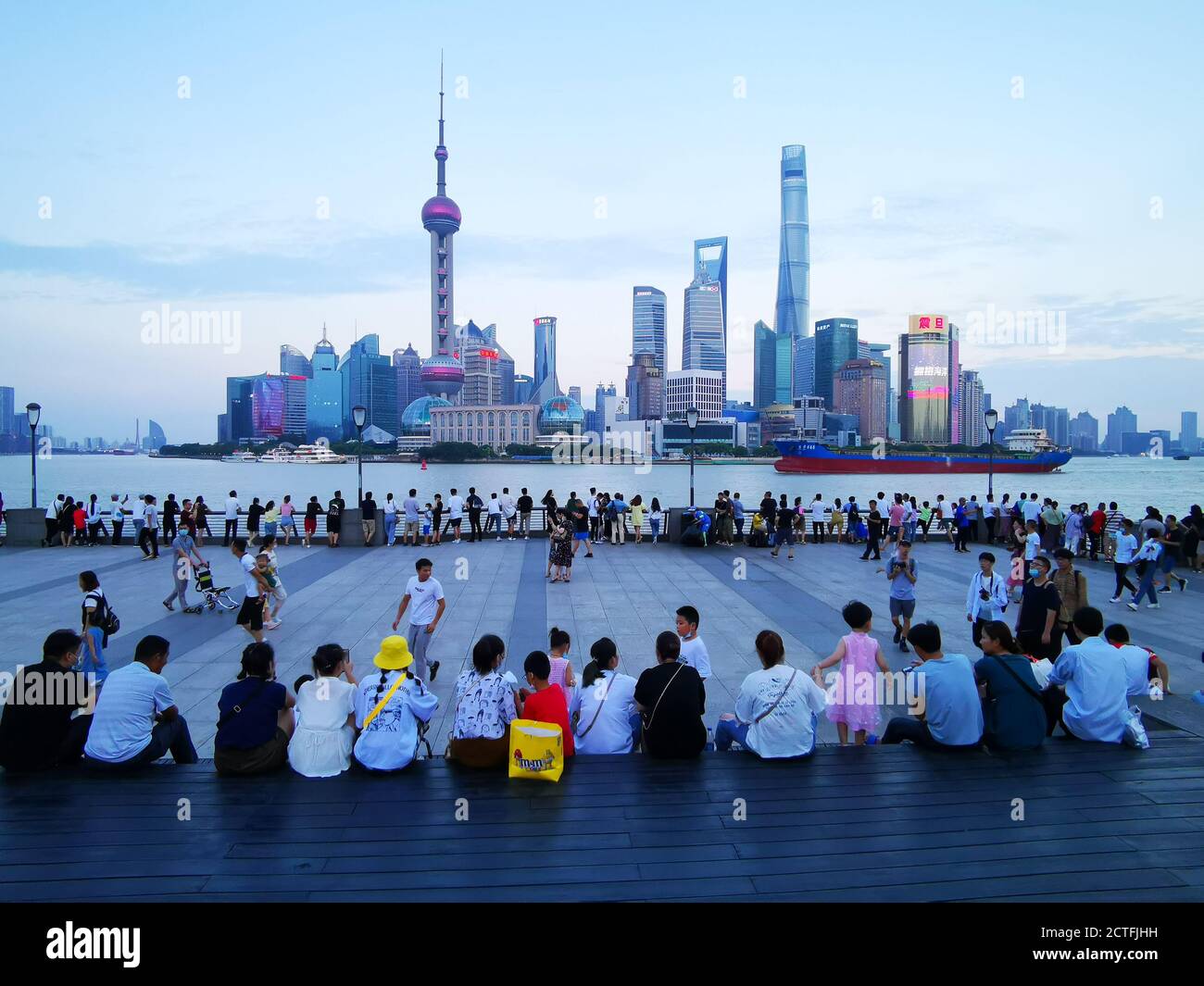 A group of tourists sit on the steps at sunset, as the temperature was ...