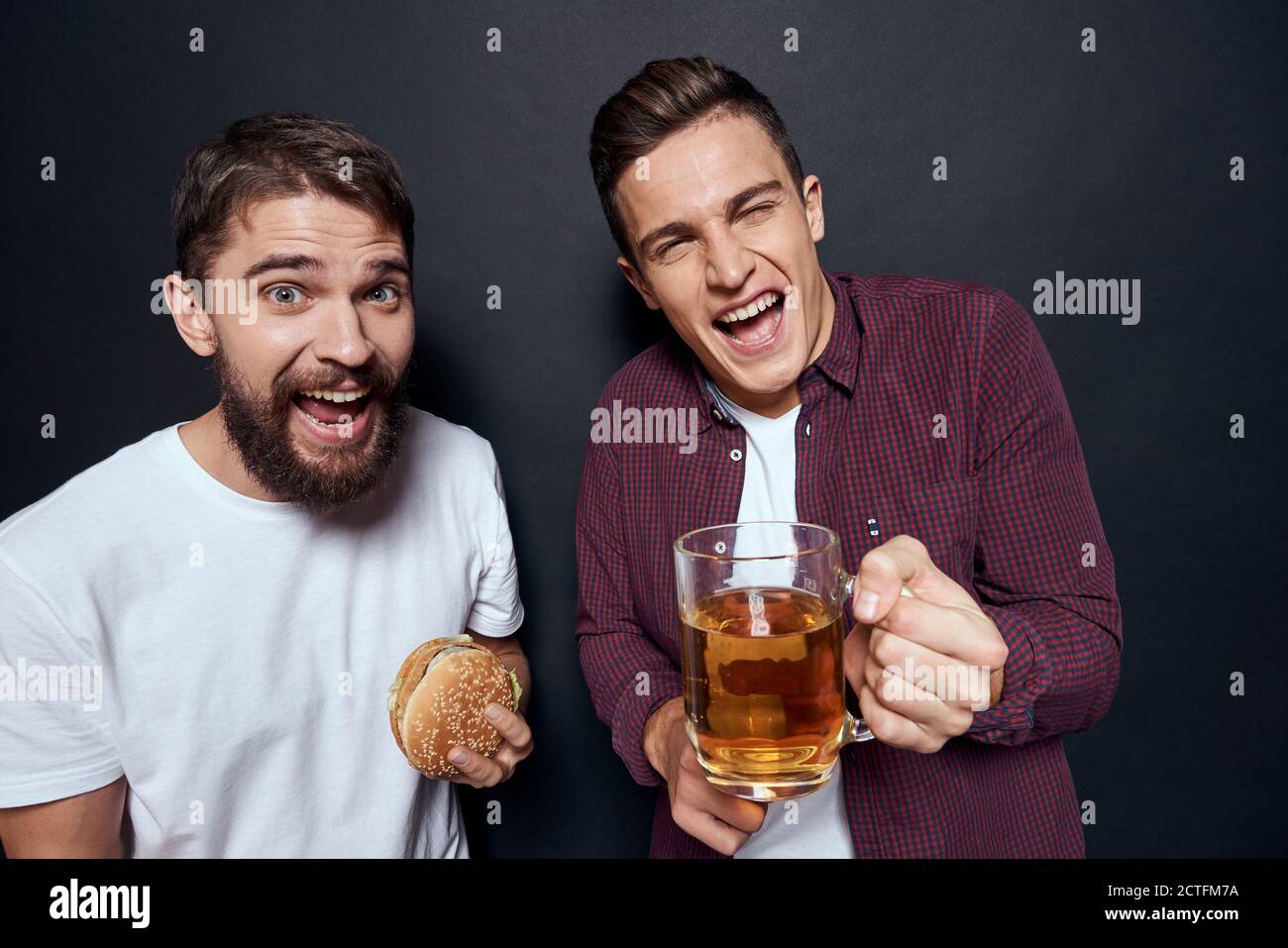 Two drunk friends drinking beer rest fun dark background Stock Photo ...