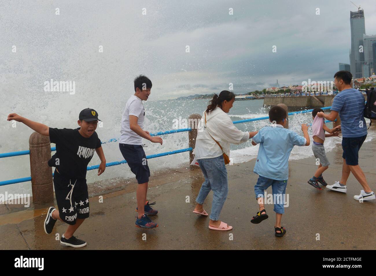 Citizens watch huge waves continuously attacking the shore as the ...