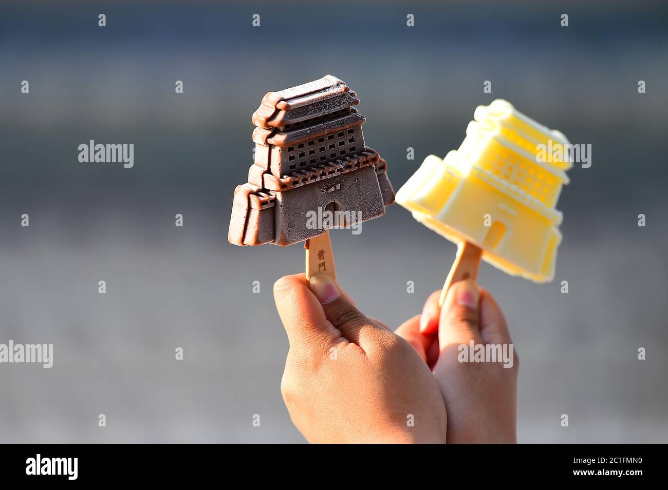 A person shows the ice-cream against the Zhengyang Gate on Qianmen ...