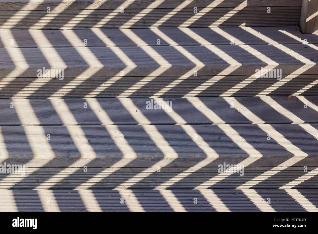 Abstract background texure of hard shadows of wooden bridge railings ...