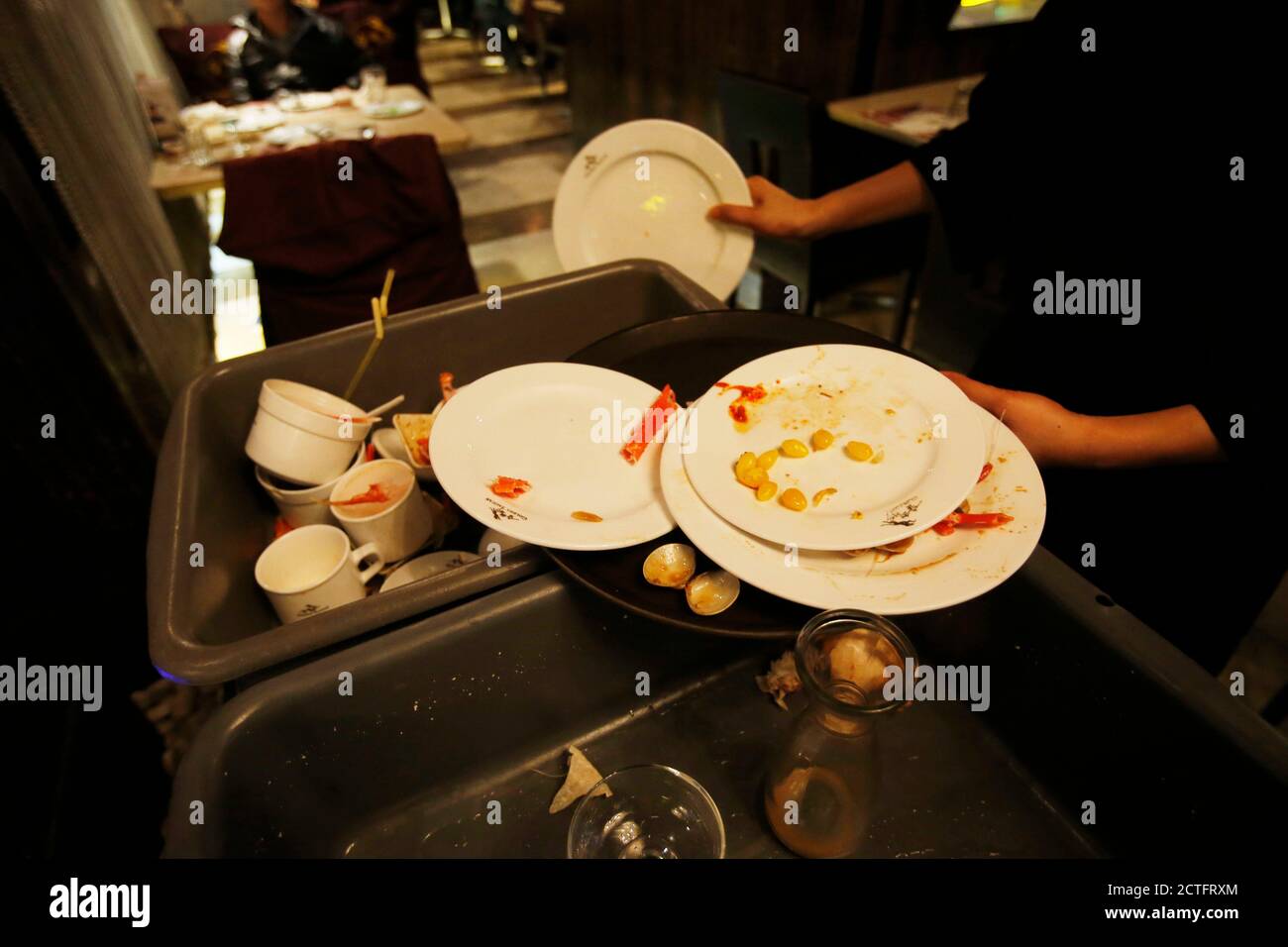 --FILE--Waiters clean plates at a buffet restaurant where food waste is ...