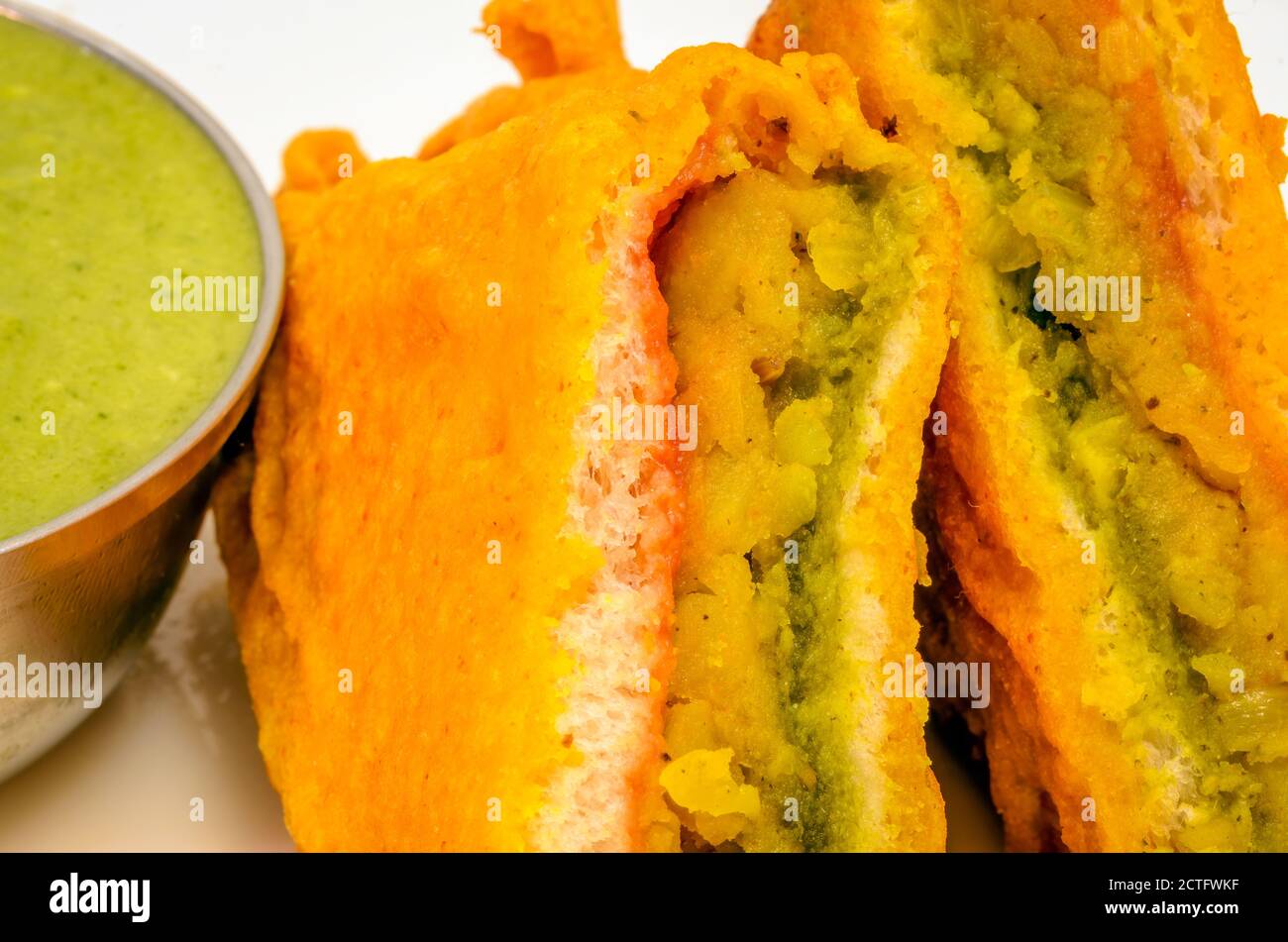 Closeup of potato masala inside a cut open bread pakoda along with ...