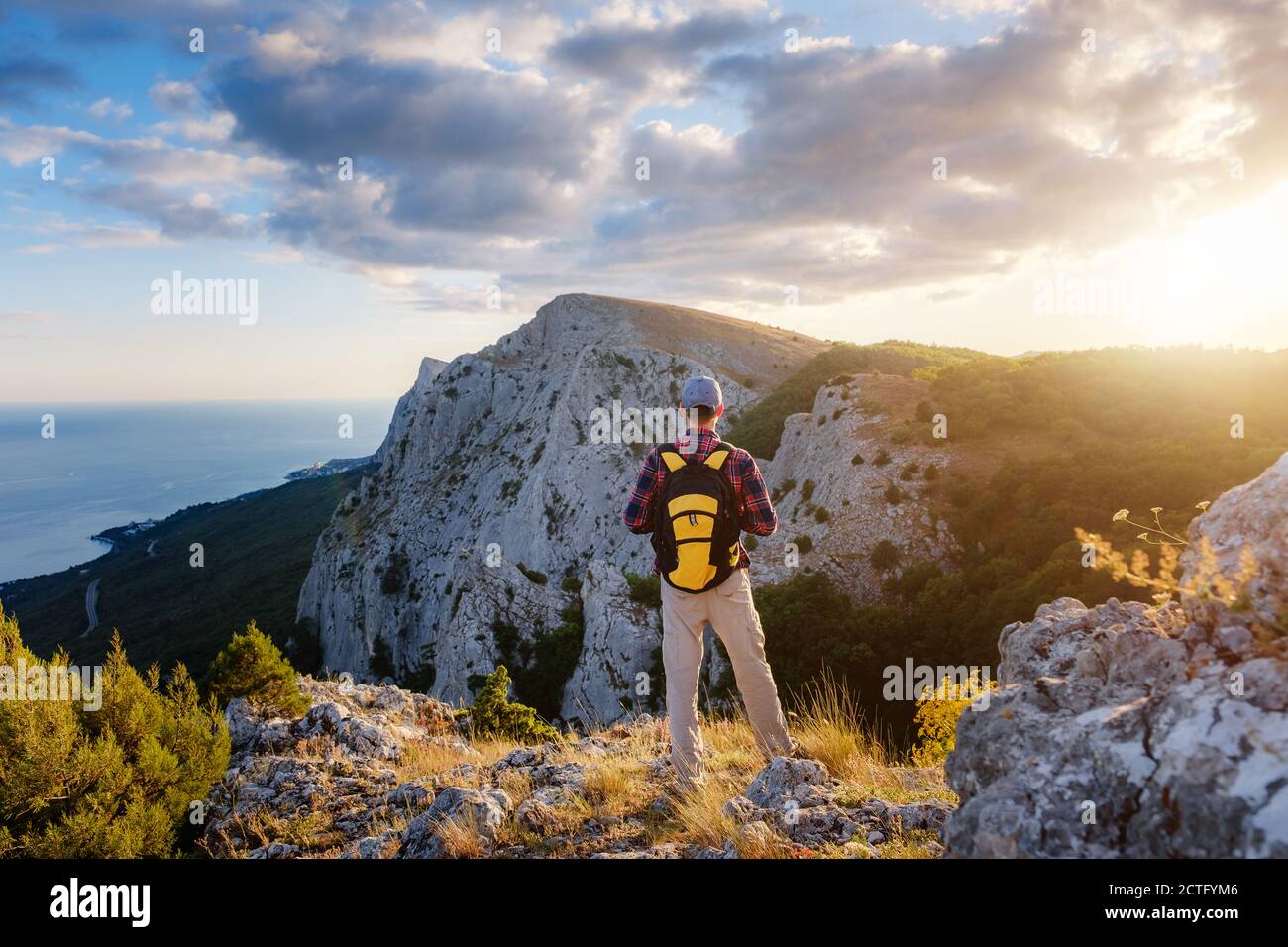 Adventurous man is on top of the mountain and enjoying the beautiful ...