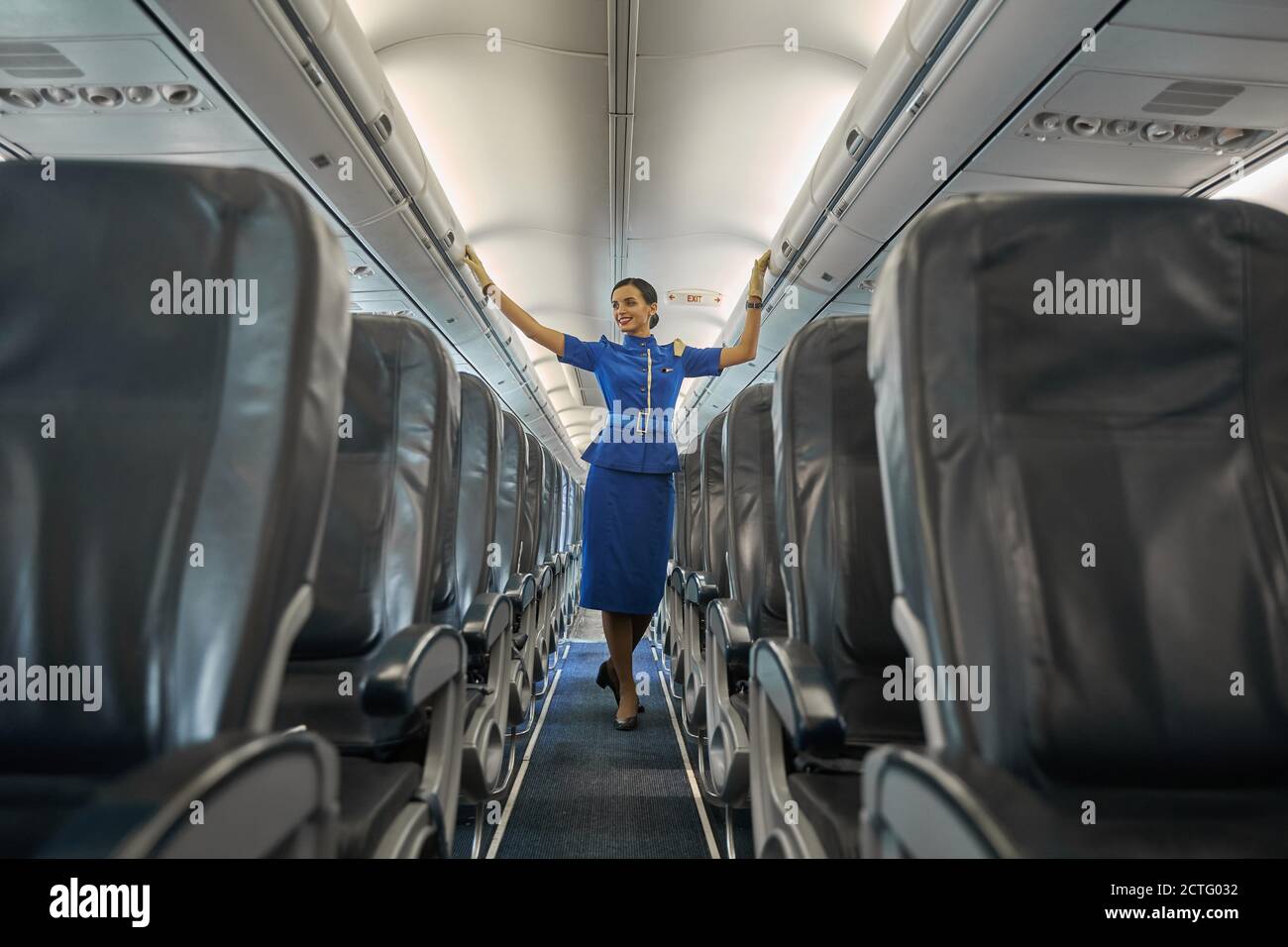 Contented professional flight hostess smiling in aircraft cabin Stock ...