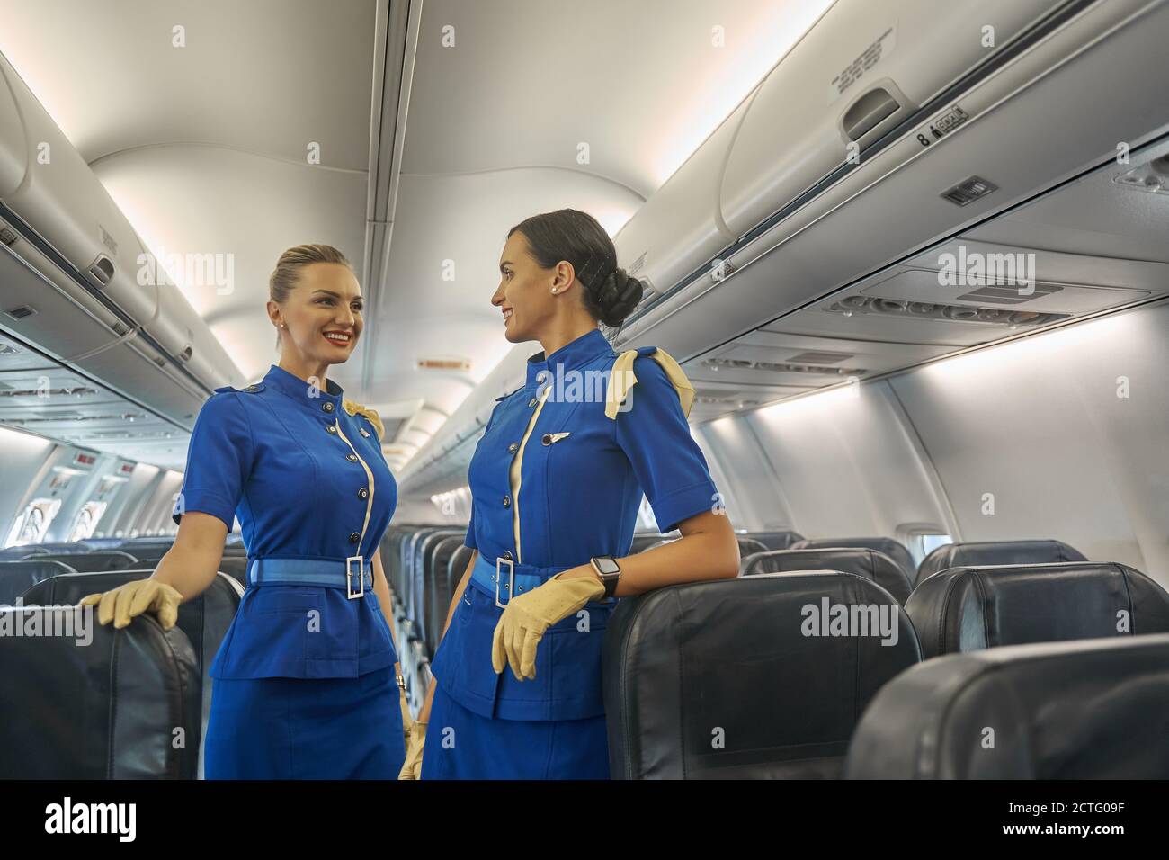 Two female cabin crew members waiting for the passengers Stock Photo ...
