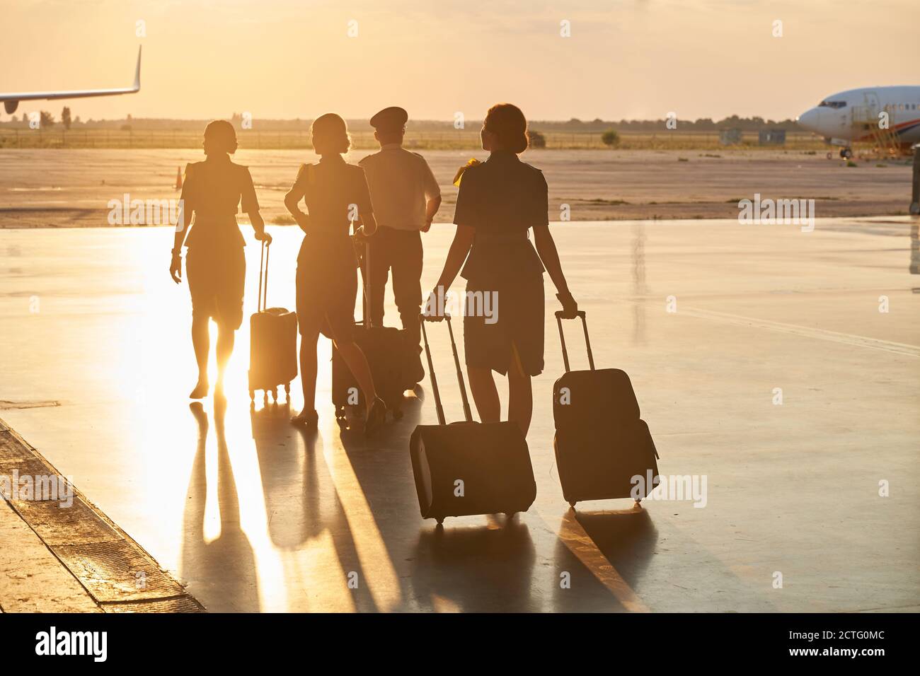 Bright evening sunlight in the airport and crew members walking Stock ...