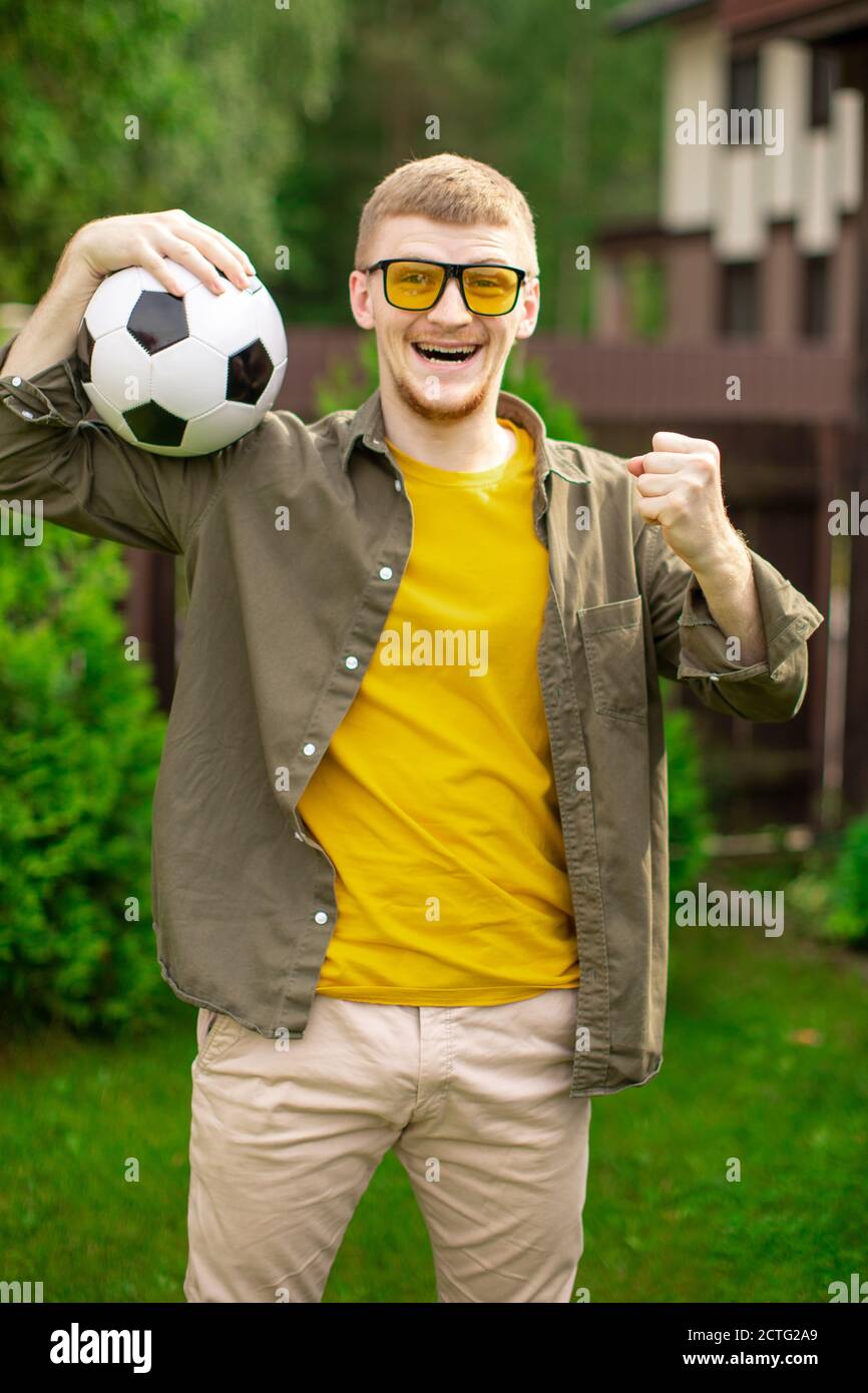 Excited young man with soccer ball smiling and screaming, Happy ...