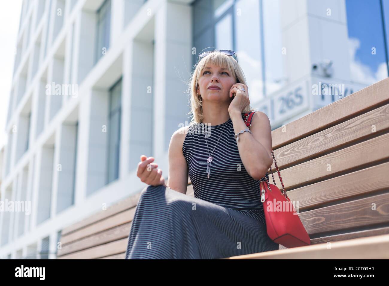 Lady sitting down on a bench hi-res stock photography and images - Alamy