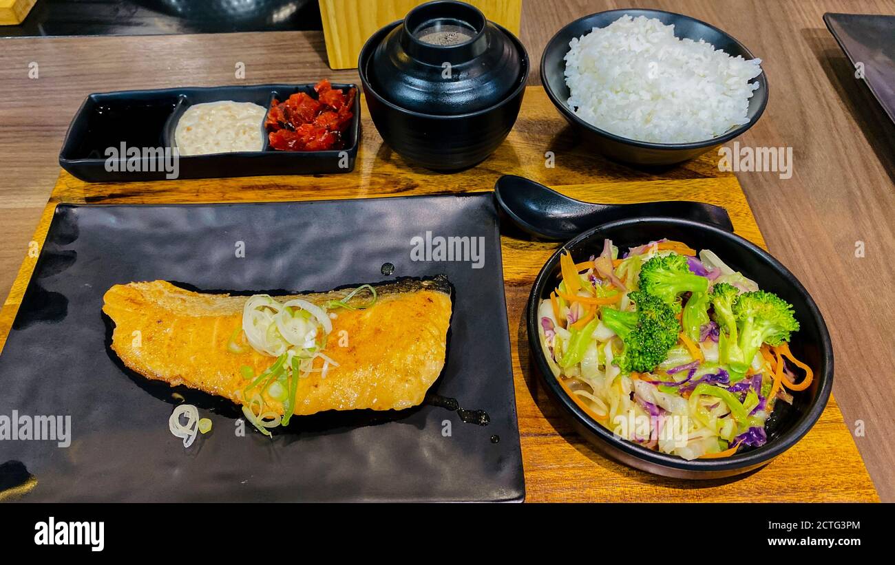 Asian fish dish with rice and vegetables Stock Photo - Alamy