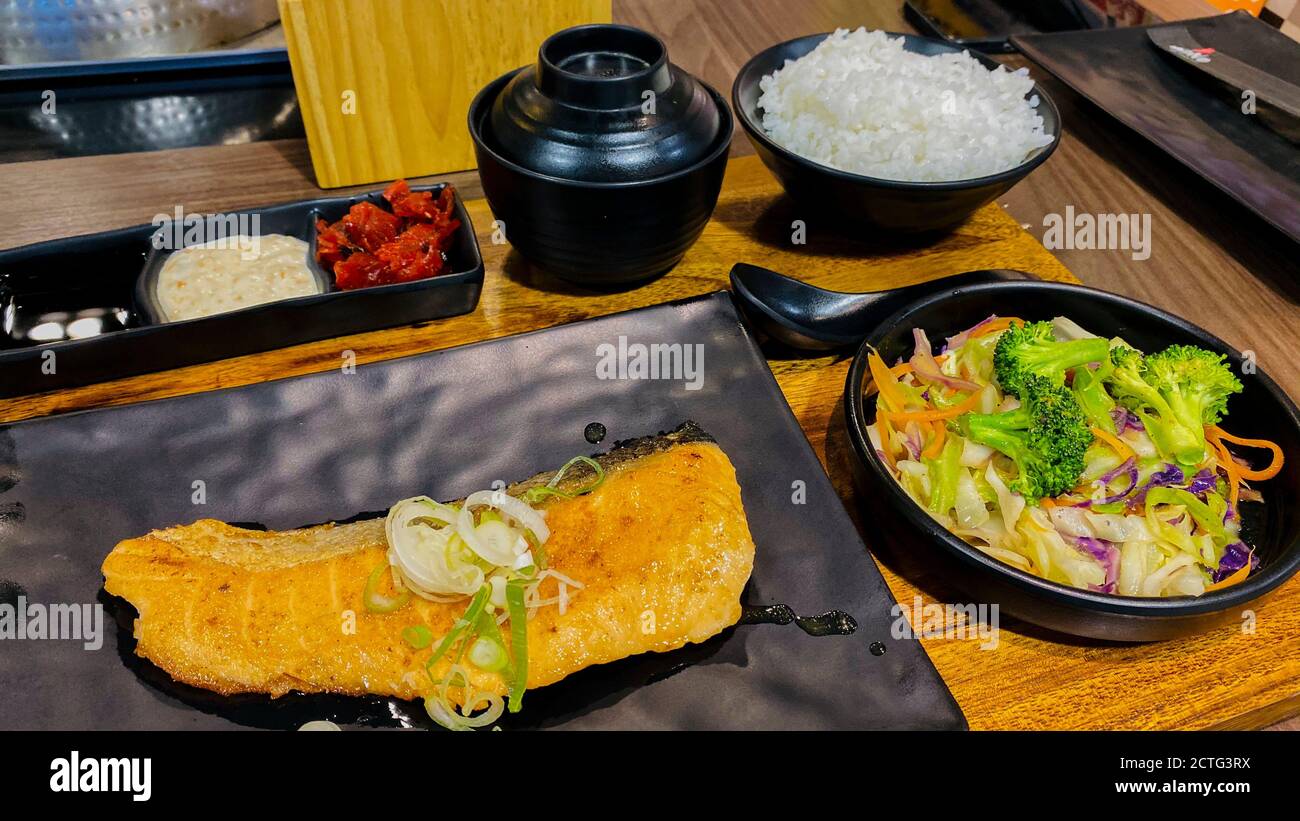 Asian fish dish with rice and vegetables Stock Photo - Alamy