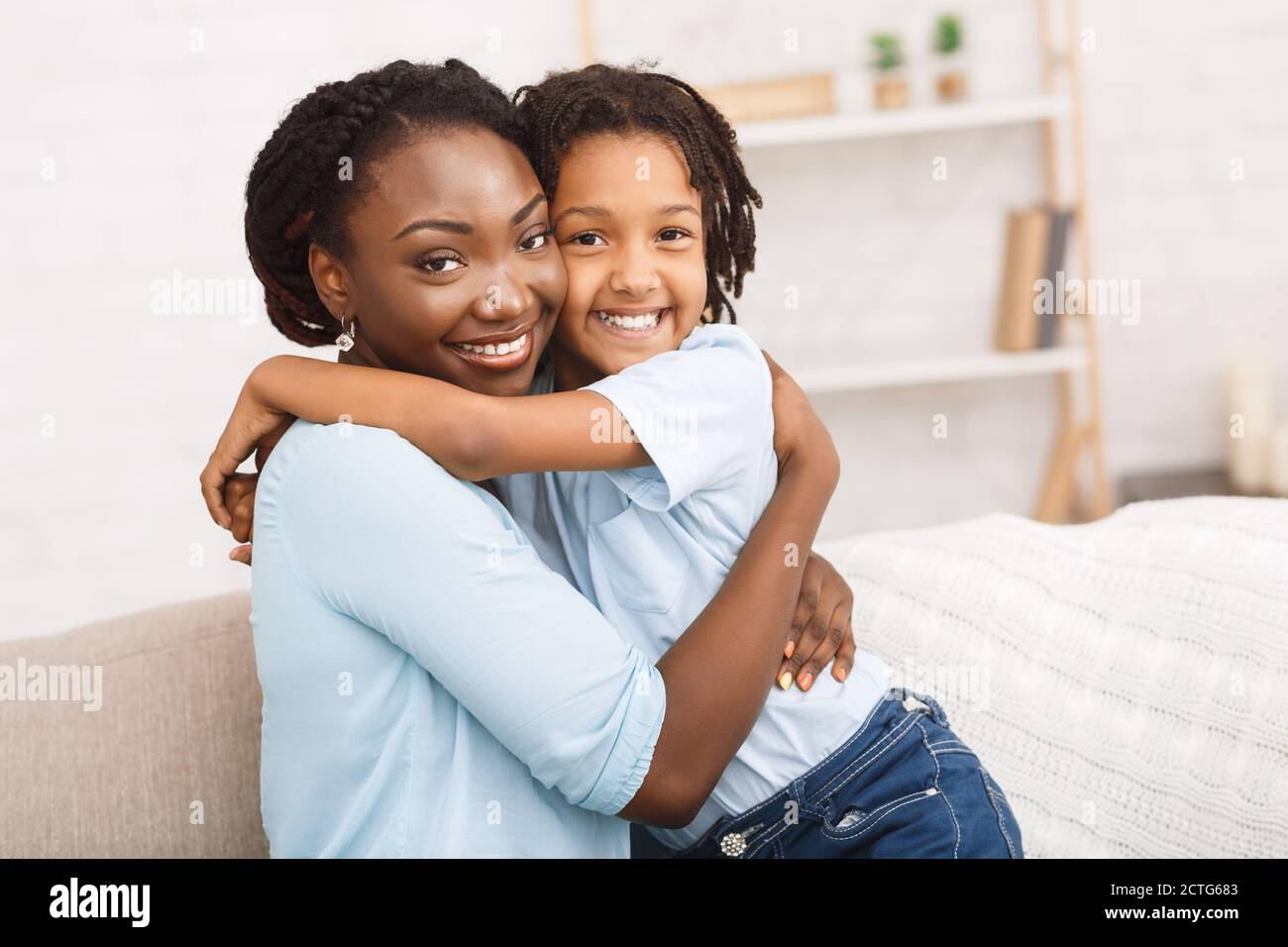 Black mother and daughter hugging at home Stock Photo - Alamy