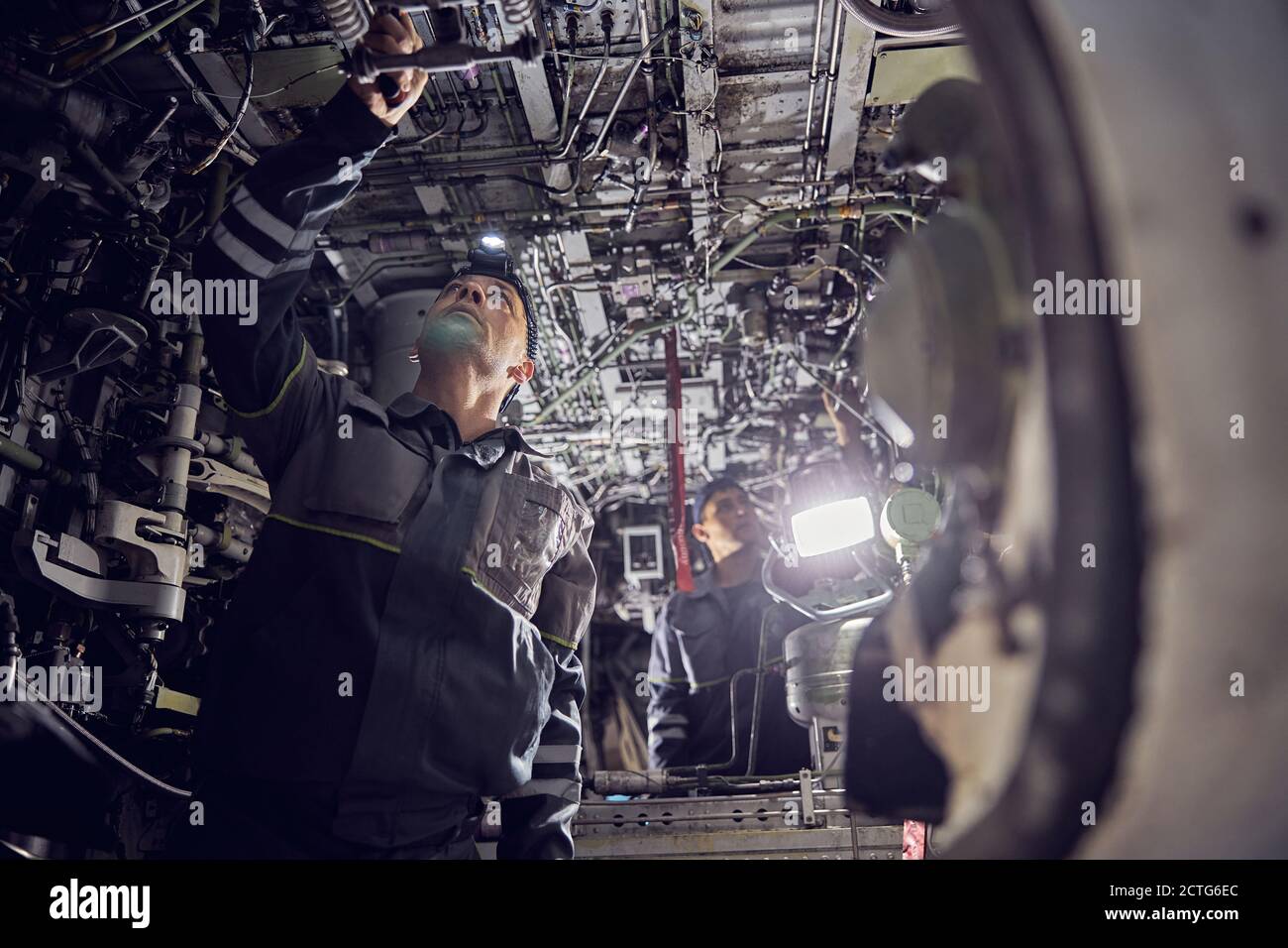 Low angle portrait of mature male mechanic wearing uniform at aircraft ...