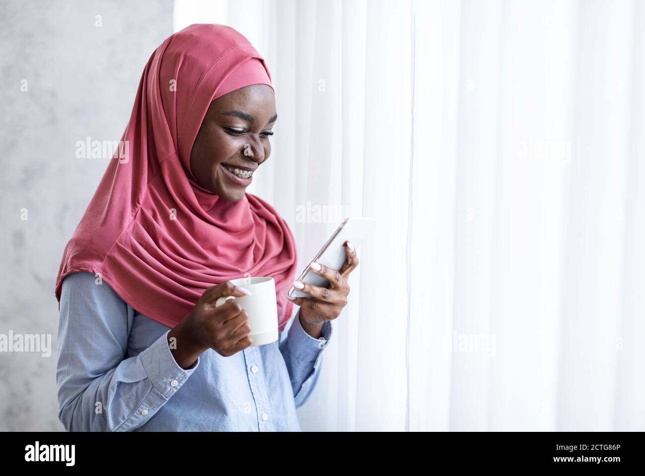 Relaxing Morning. Smiling Black Muslim Woman With Coffee And Smartphone ...