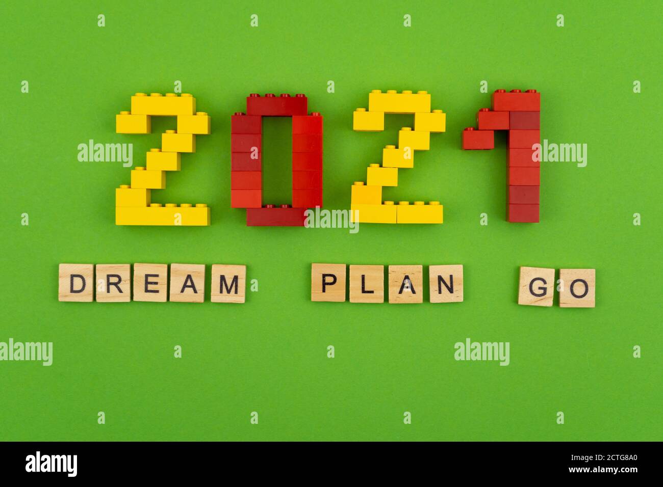 The phrase dream plan do is lined with wooden letters on a green ...