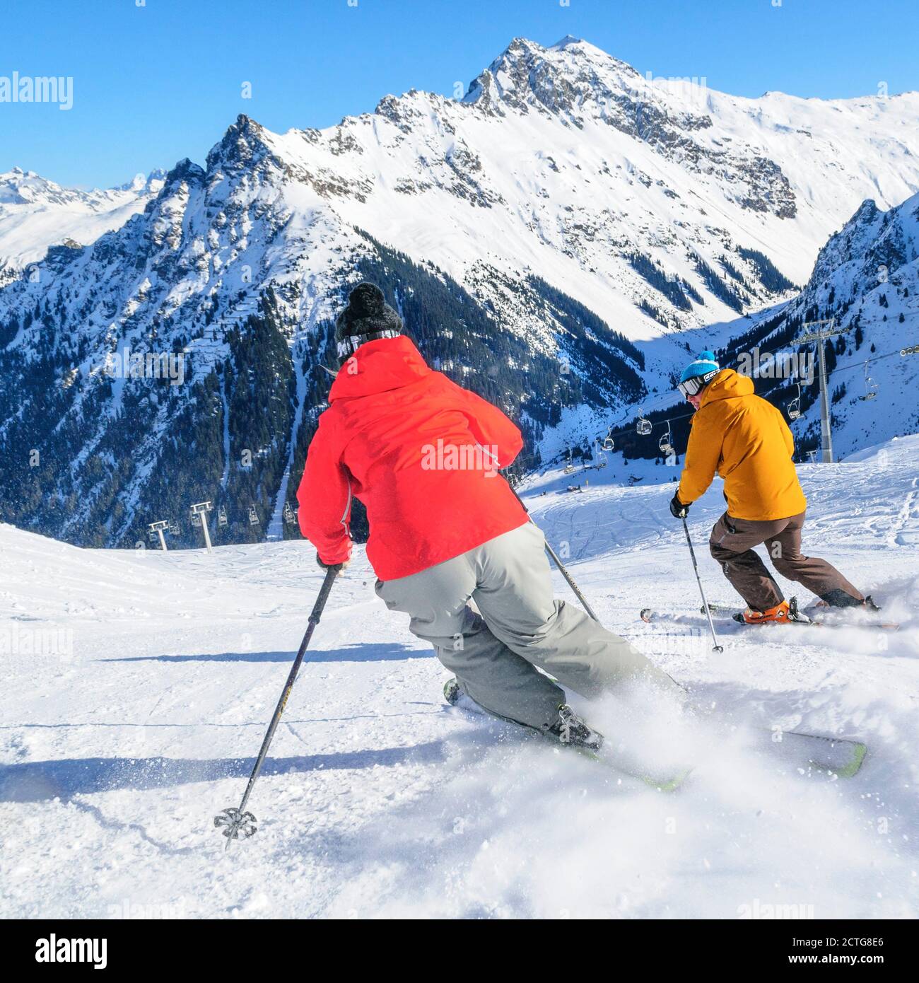 Young couple skiing together on perfect slope in austrian alps Stock ...