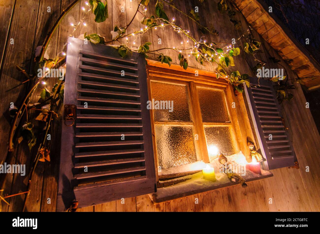 Romantic lightened window of a wooden hut in wintry scenery Stock Photo ...